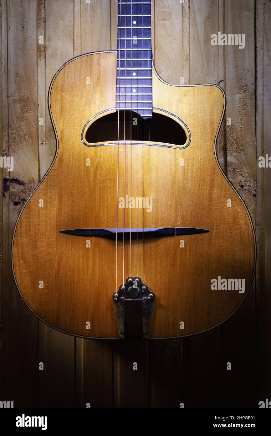 Beautifully gipsy jazz acoustic guitar details, hanged on wooden wall ...