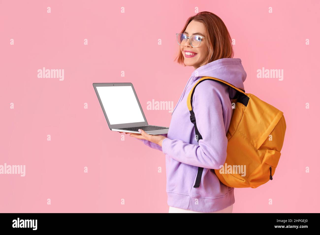 Female student with laptop on pink background Stock Photo - Alamy