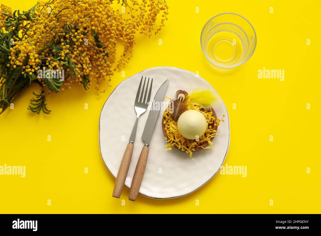 Stylish table setting for Easter celebration with mimosa flowers on ...