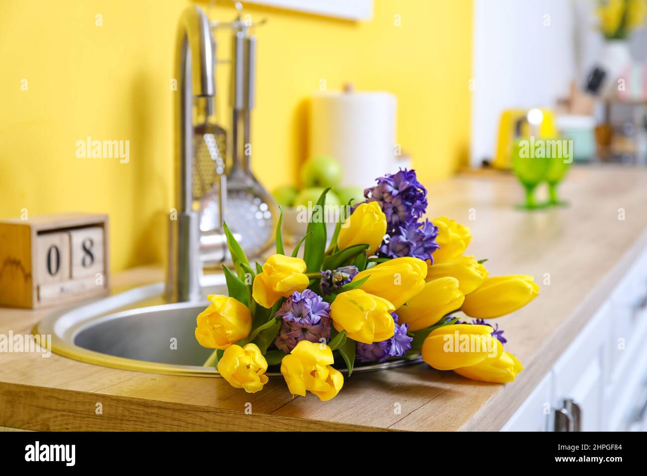 Kitchen counter with bouquet of flowers in sink near color wall Stock ...