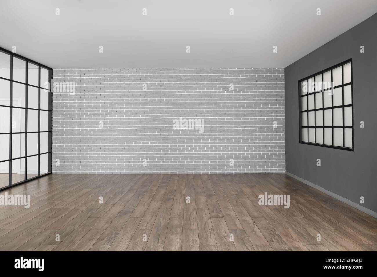 View of big empty room with grey brick wall and window Stock Photo - Alamy