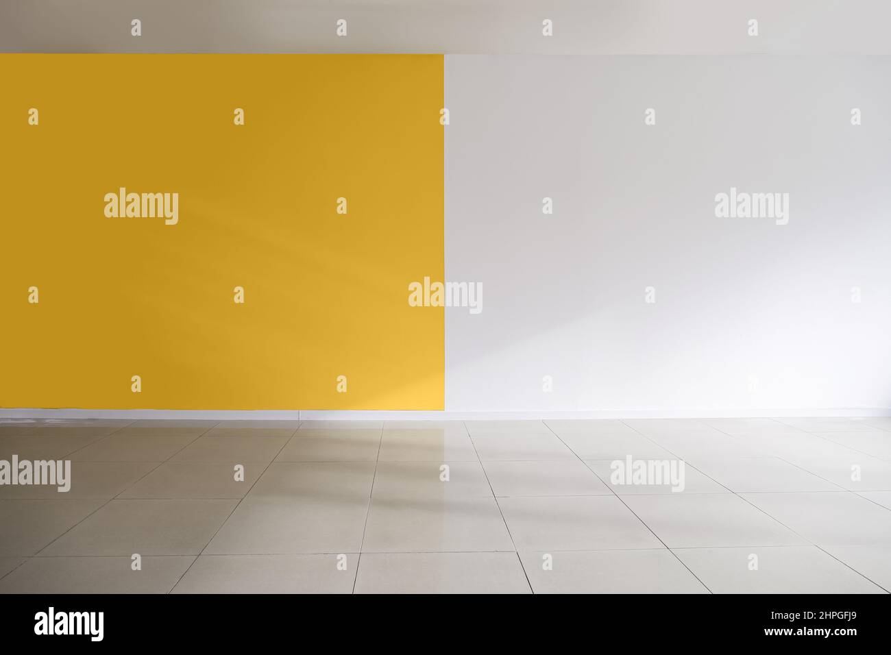 View of yellow and white wall in big empty room Stock Photo - Alamy