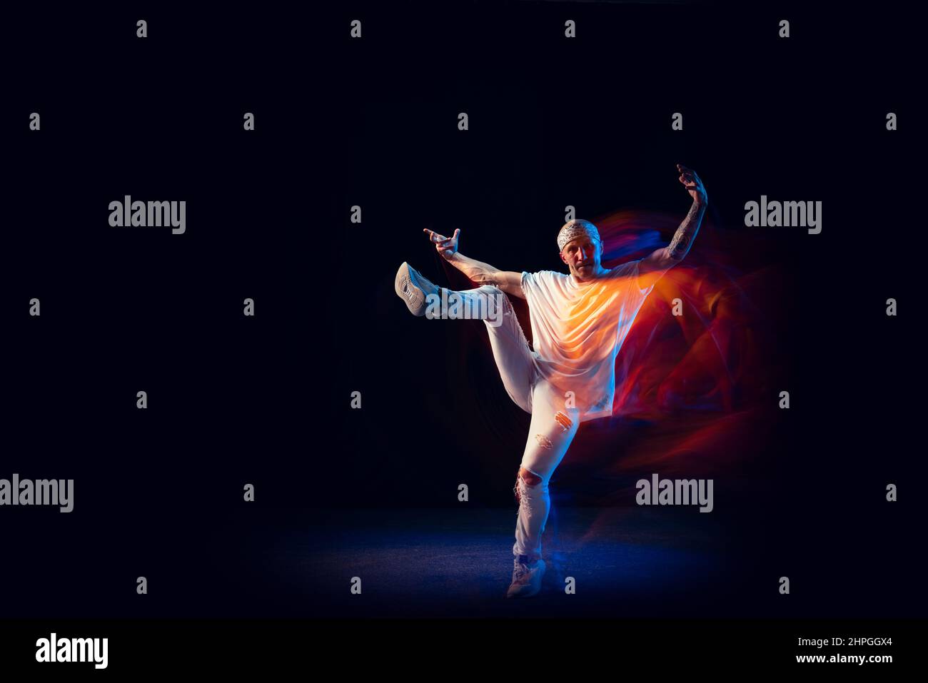 Hip-hop moves. Bald man in white jeans and tee dancing hip-hop isolated ...