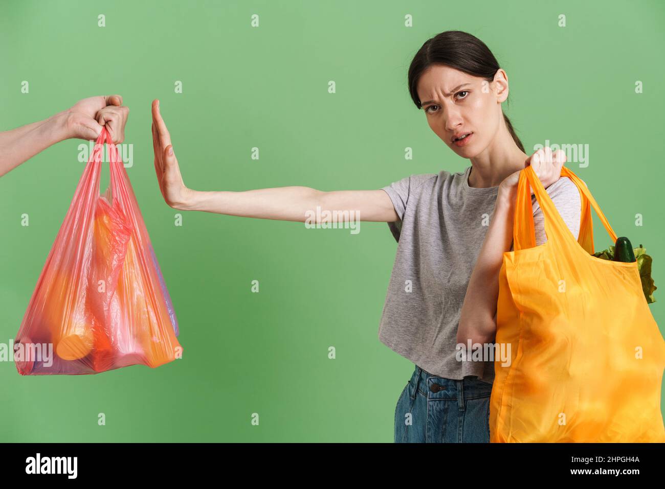 Young woman making stop gesture while posing with textile bag isolated ...