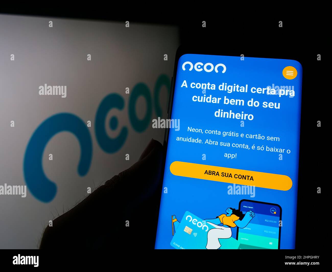 Person holding cellphone with website of Brazilian fintech company Neon ...