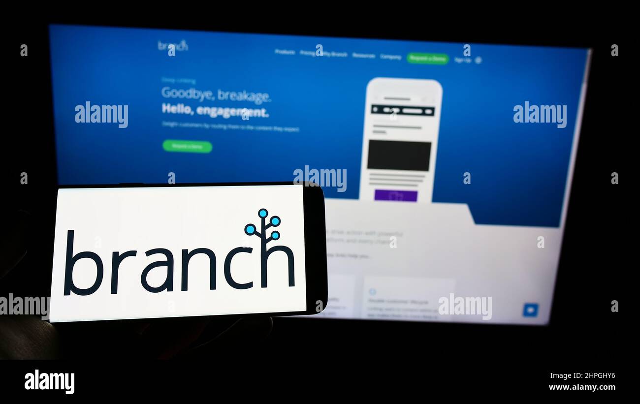 Person holding cellphone with logo of US company Branch Metrics Inc ...