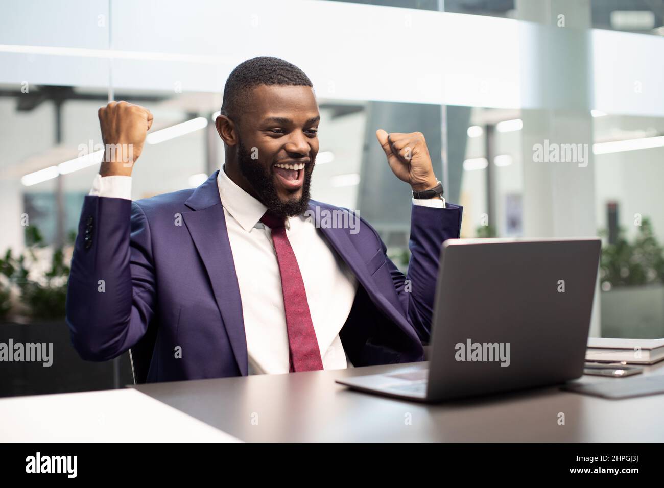 Happy african american boss using computer, gesturing Stock Photo - Alamy