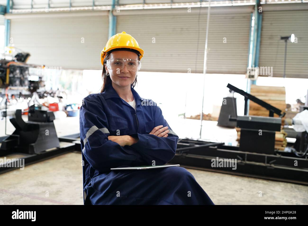 Female industrial worker working with manufacturing equipment in a ...