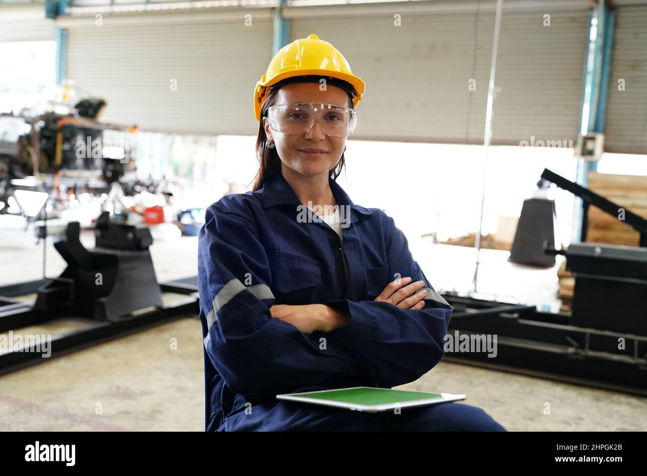 Female industrial worker working with manufacturing equipment in a ...