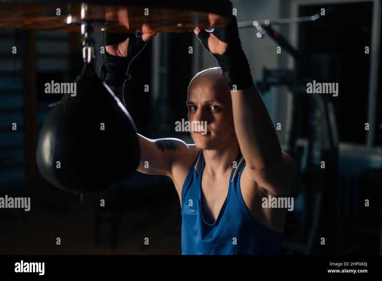 Portrait of brutal bald boxer male in boxing defence tape resting near ...