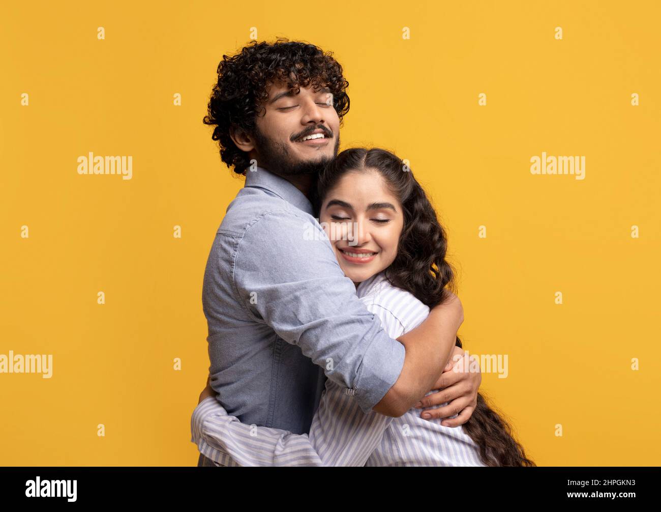 Portrait of affectionate indian couple hugging with closed eyes while ...