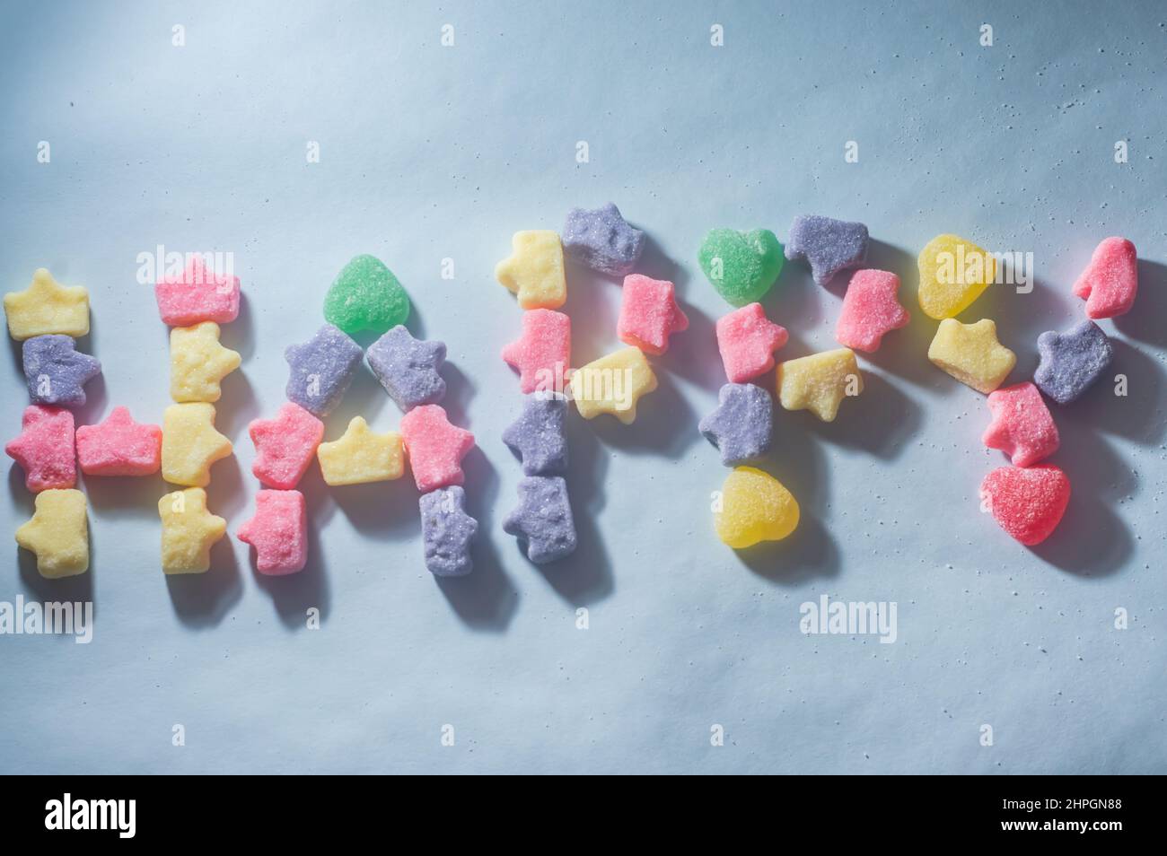 Colorful sweets varied with the word "Happy" written,light blue ...