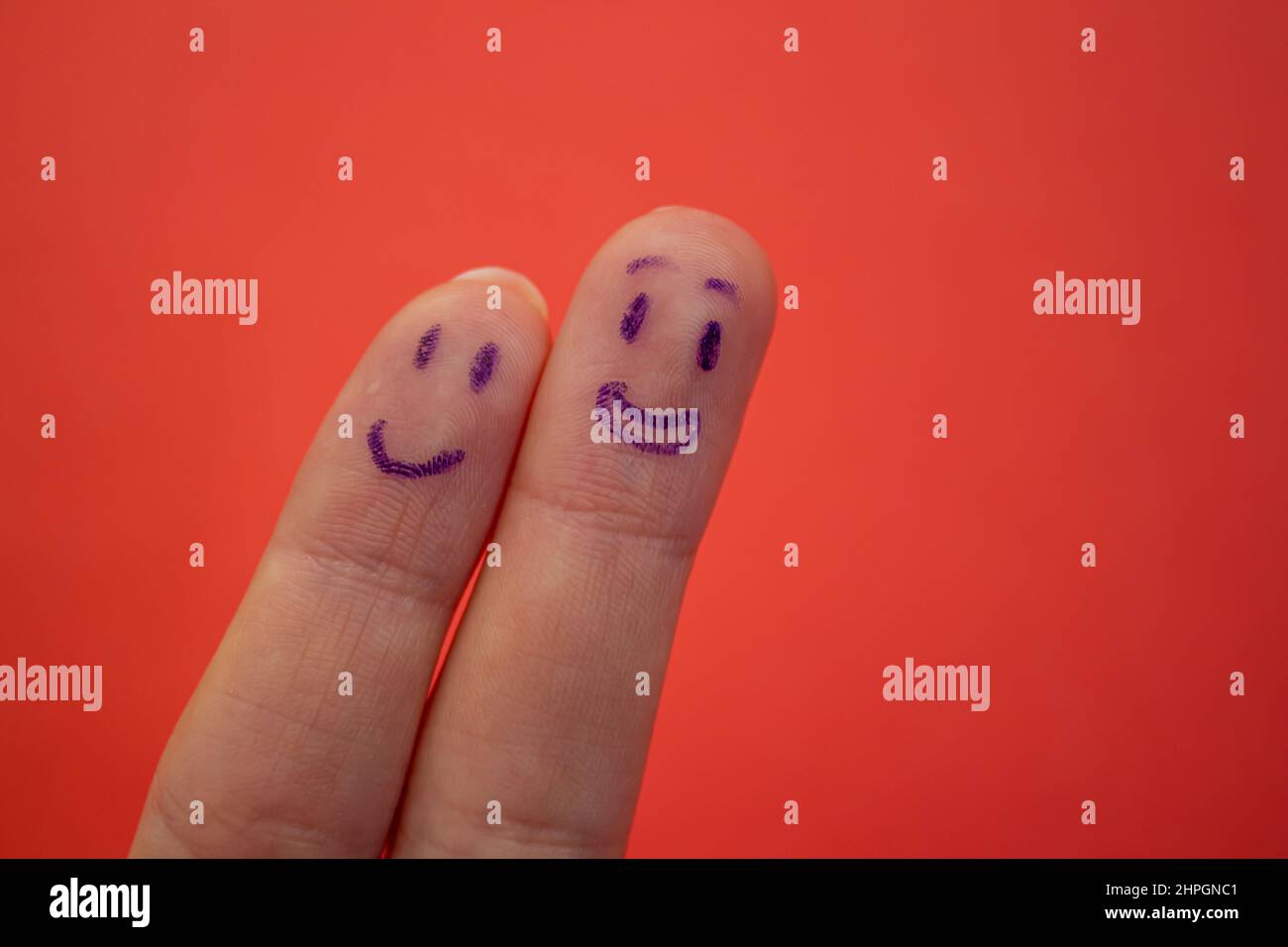 Smiley faces drawn on fingers isolated on red background. Happiness and ...