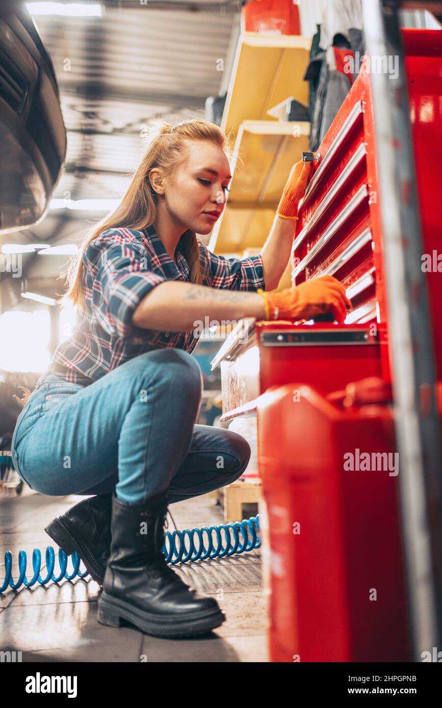 Female auto mechanic. beautiful young red-headed girl in working ...