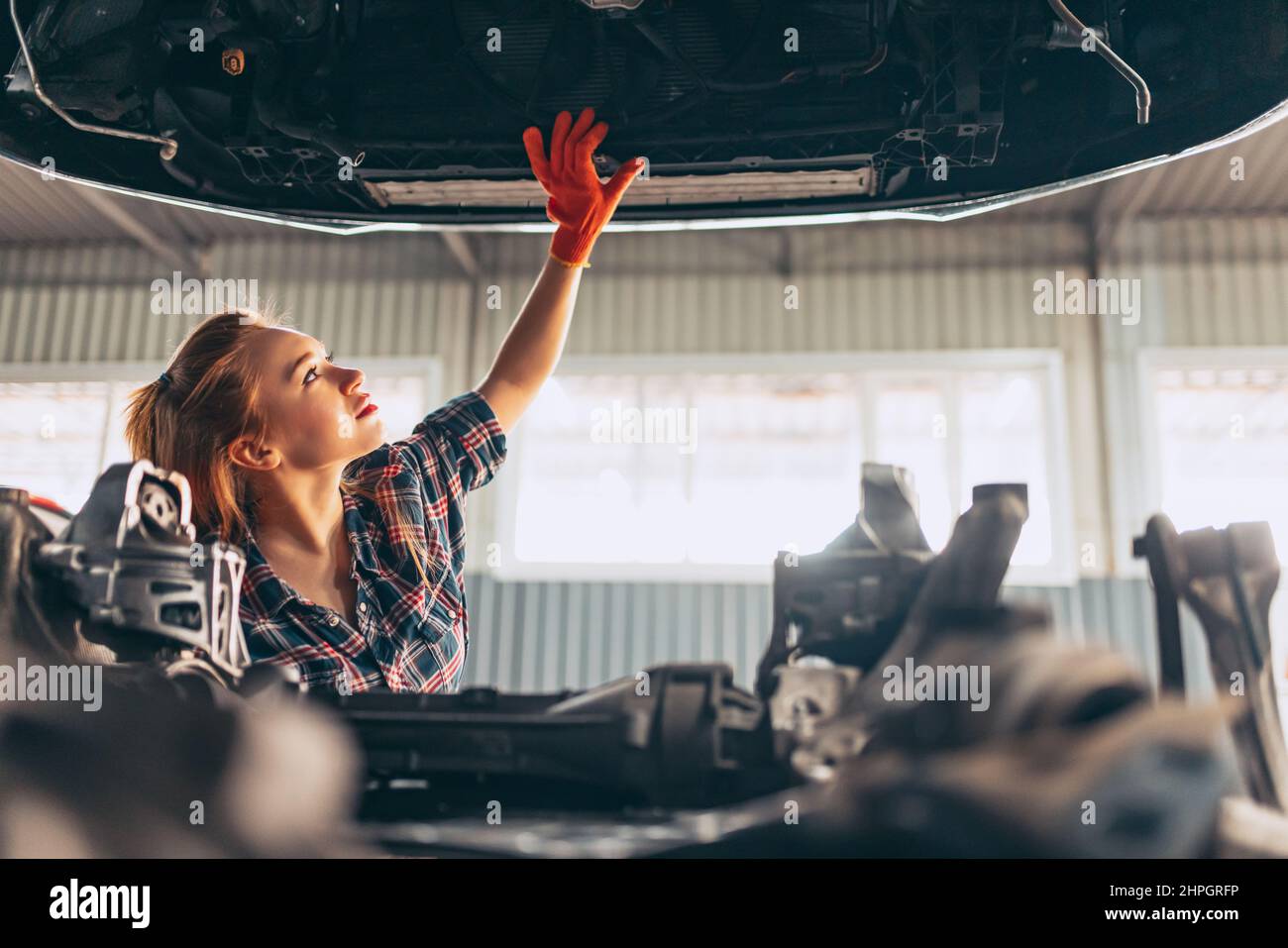 Car reapir. Young red-headed girl, auto mechanic working at auto ...