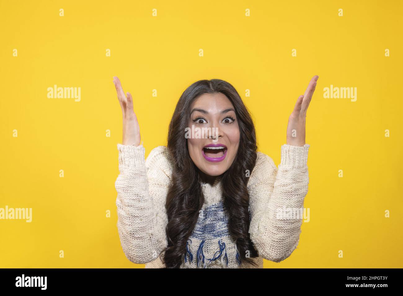 happy young woman with surprised expression on isolated yellow ...