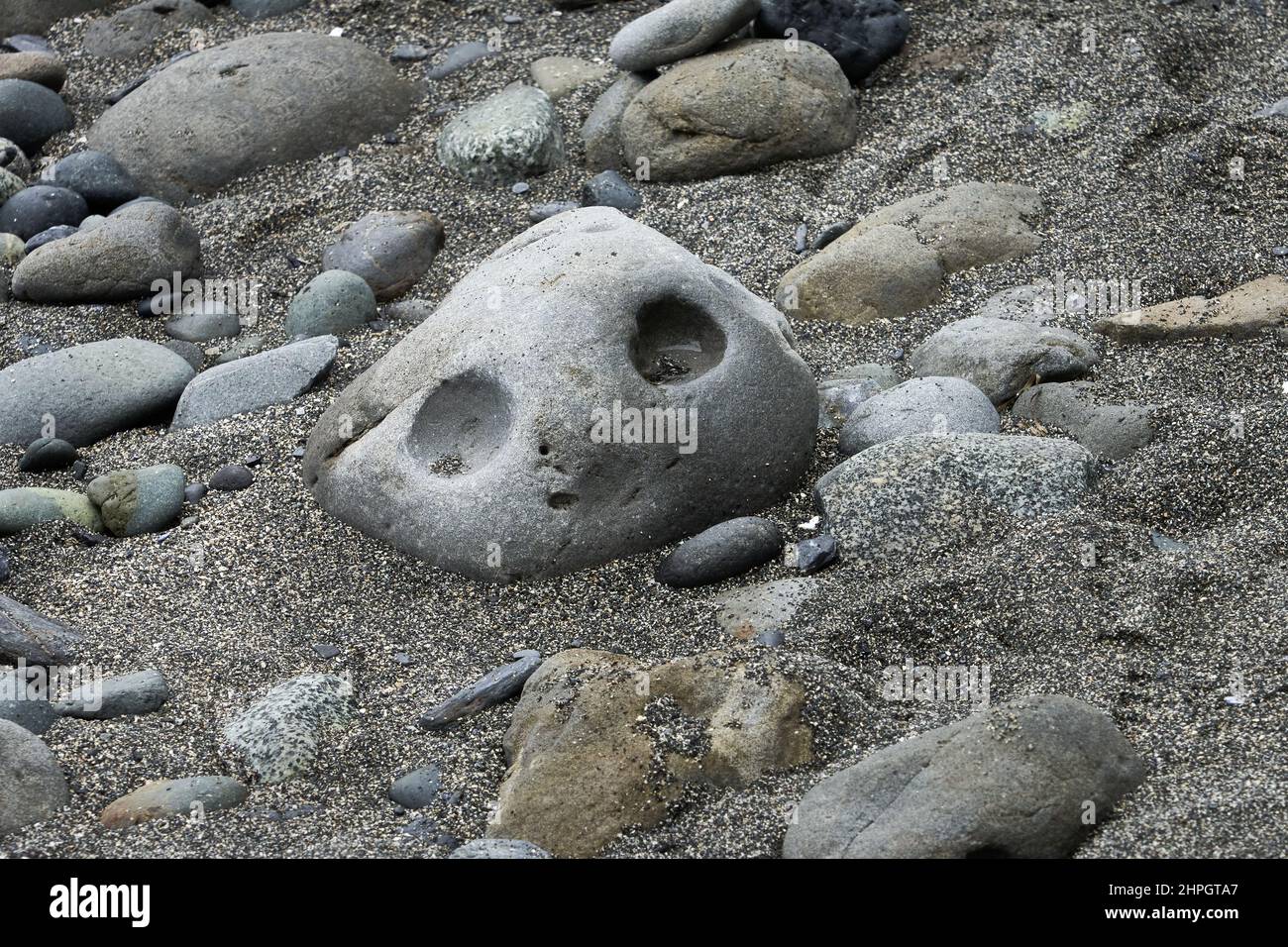 Rock with a face on an ocean beach Stock Photo - Alamy