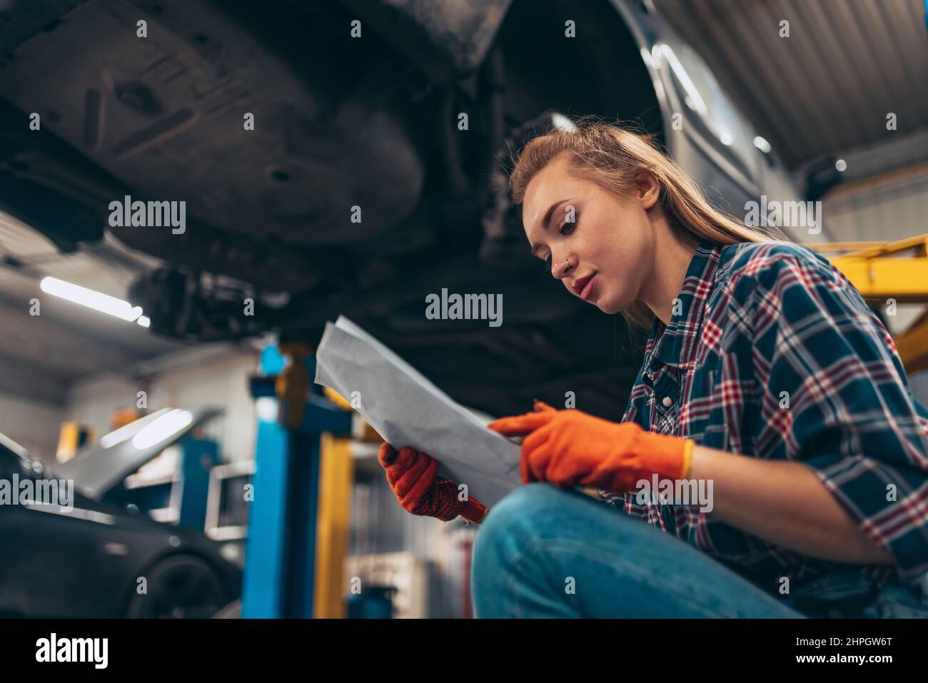 Portrait of beautiful young red-headed girl, auto mechanic at auto ...