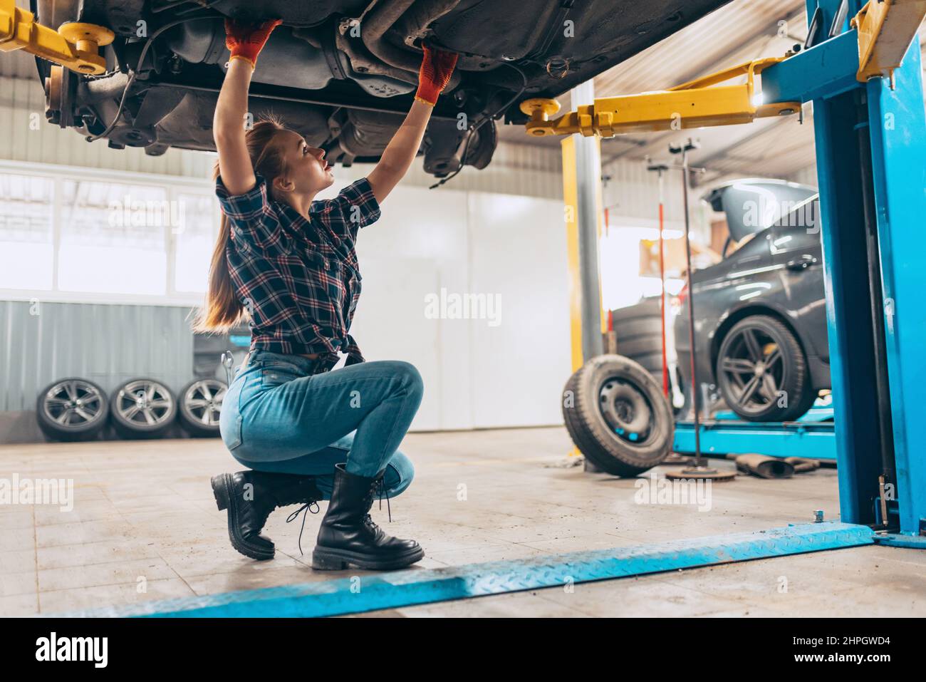 Portrait of beautiful young red-headed girl, auto mechanic at auto ...