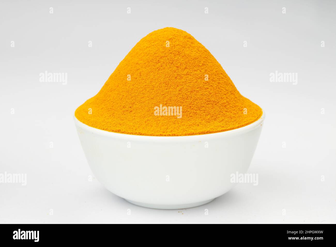 Turmeric powder arranged in a white bowl with white texture or ...