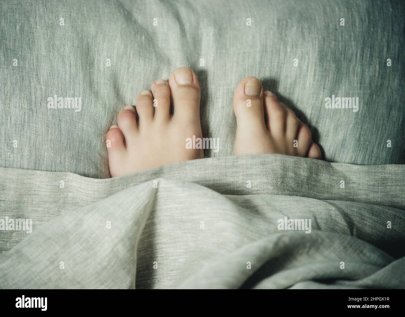 feet under the blanket close-up Stock Photo - Alamy