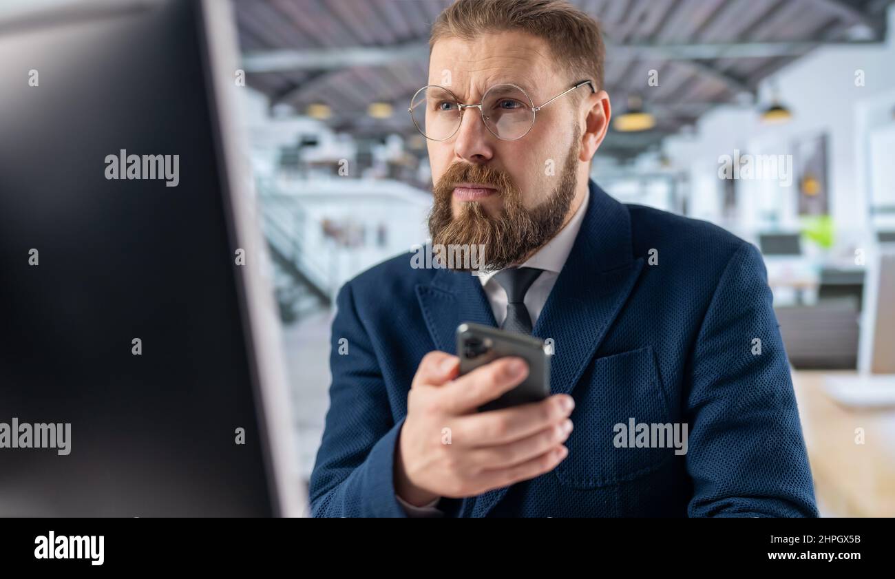 Man using mobile and pc at office Stock Photo - Alamy