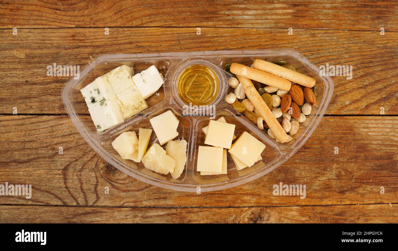 Set of food in a plastic container. Cheese plate for a picnic on a ...