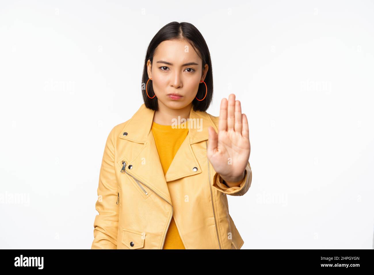 Serious and concerned asian girl extending palm hand, stop gesture ...