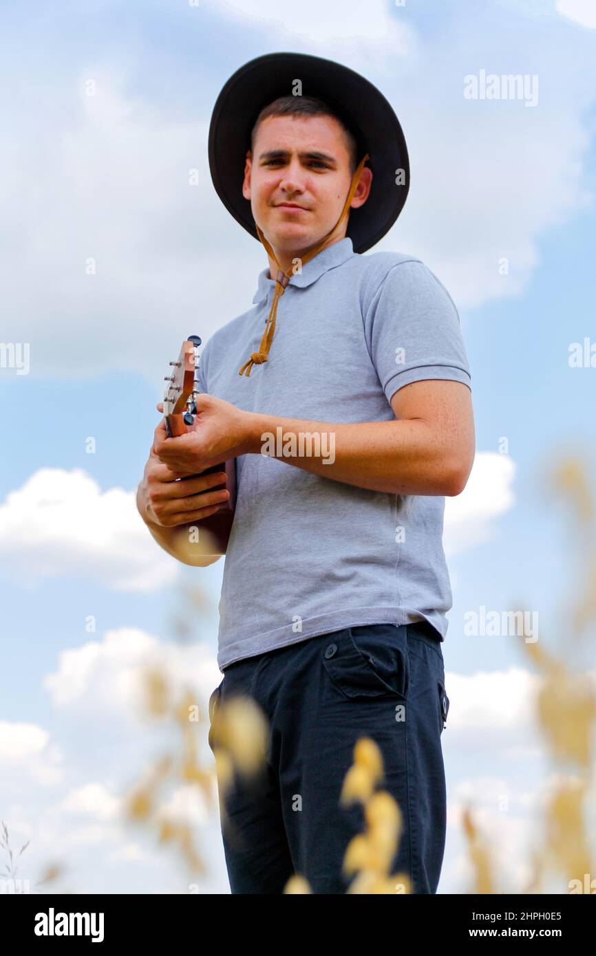 Lifestyle musician. Young beautiful caucasian man playing ukulele ...