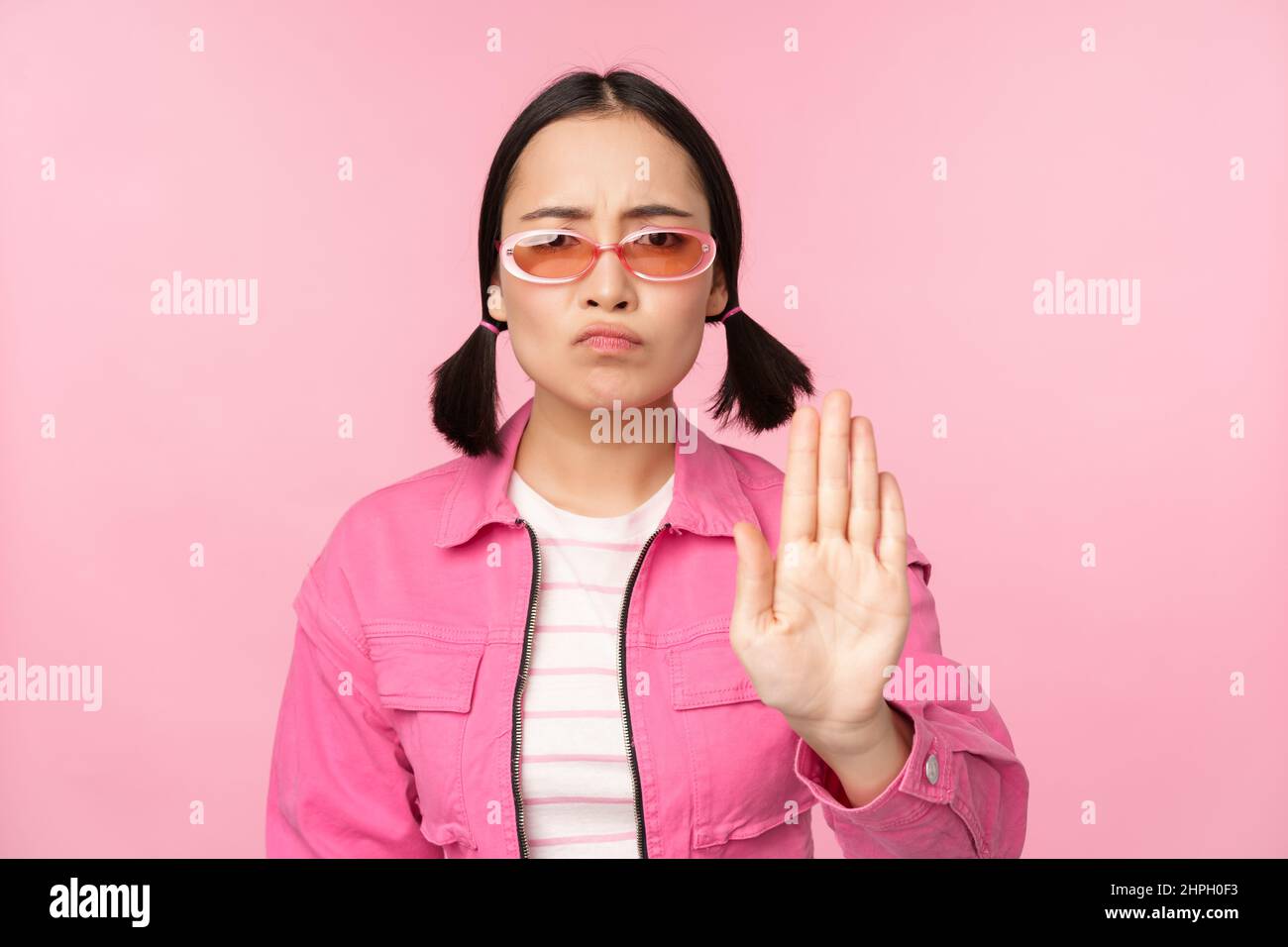 Image of serious, stylish asian girl in sunglasses, showing stop ...