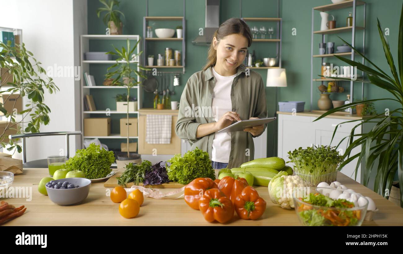 Young Woman Makes a Diet Plan of Correct Nutrition Using a Tablet in ...