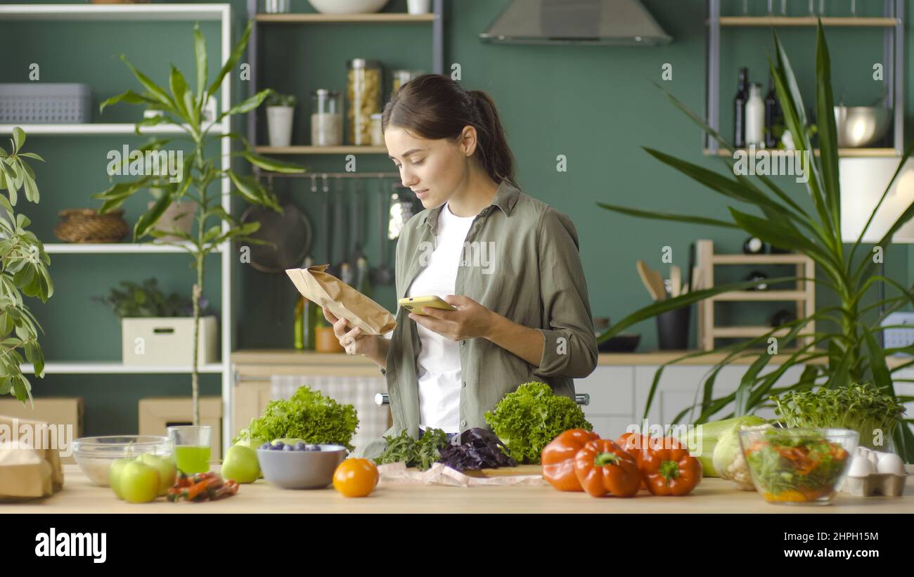 A Young Woman is Studying the Composition of Products Using a Mobile ...