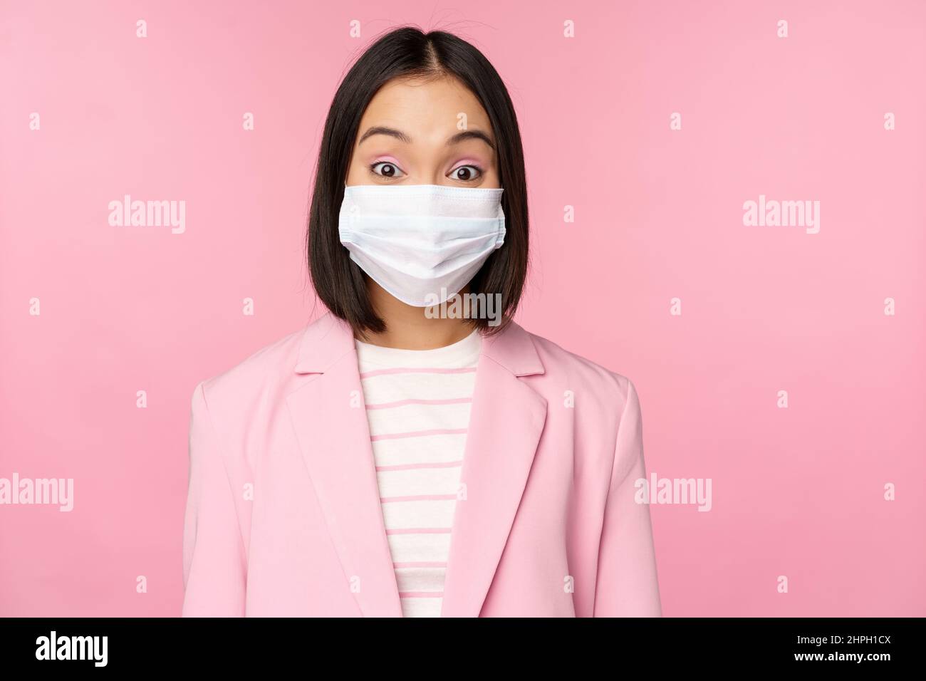 Portrait of asian businesswoman in medical face mask, wearing suit ...