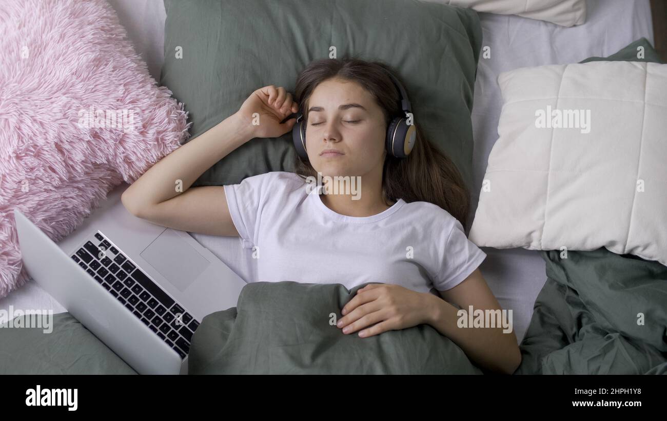 Young Businesswoman Eating a Glazed Donut While Working on Laptop in ...