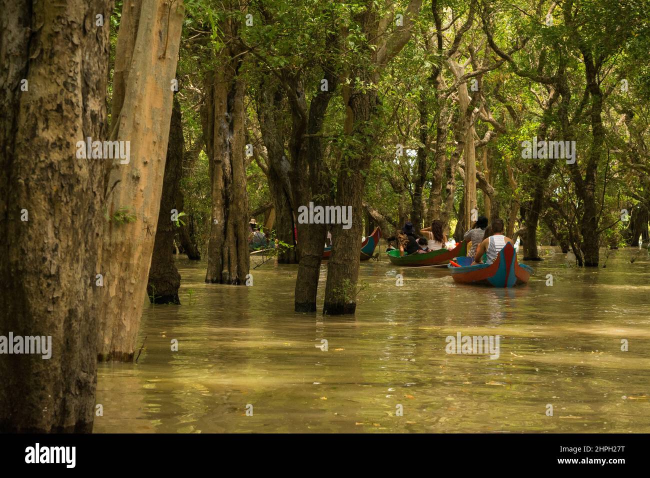 Long boats or canoes paddling and exploring the floating flooded ...