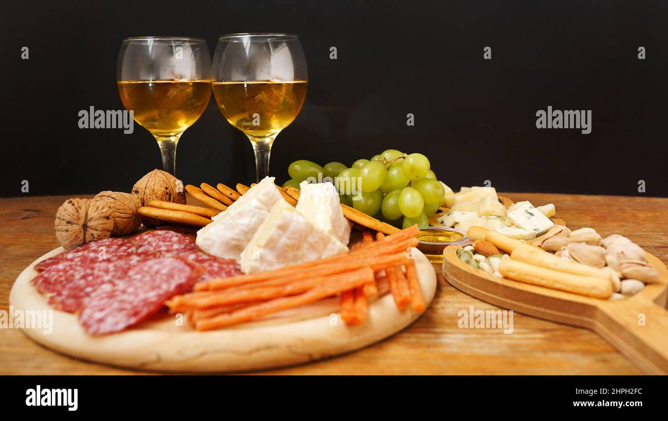 Cheese platter with assorted cheeses, grapes, nuts over black ...