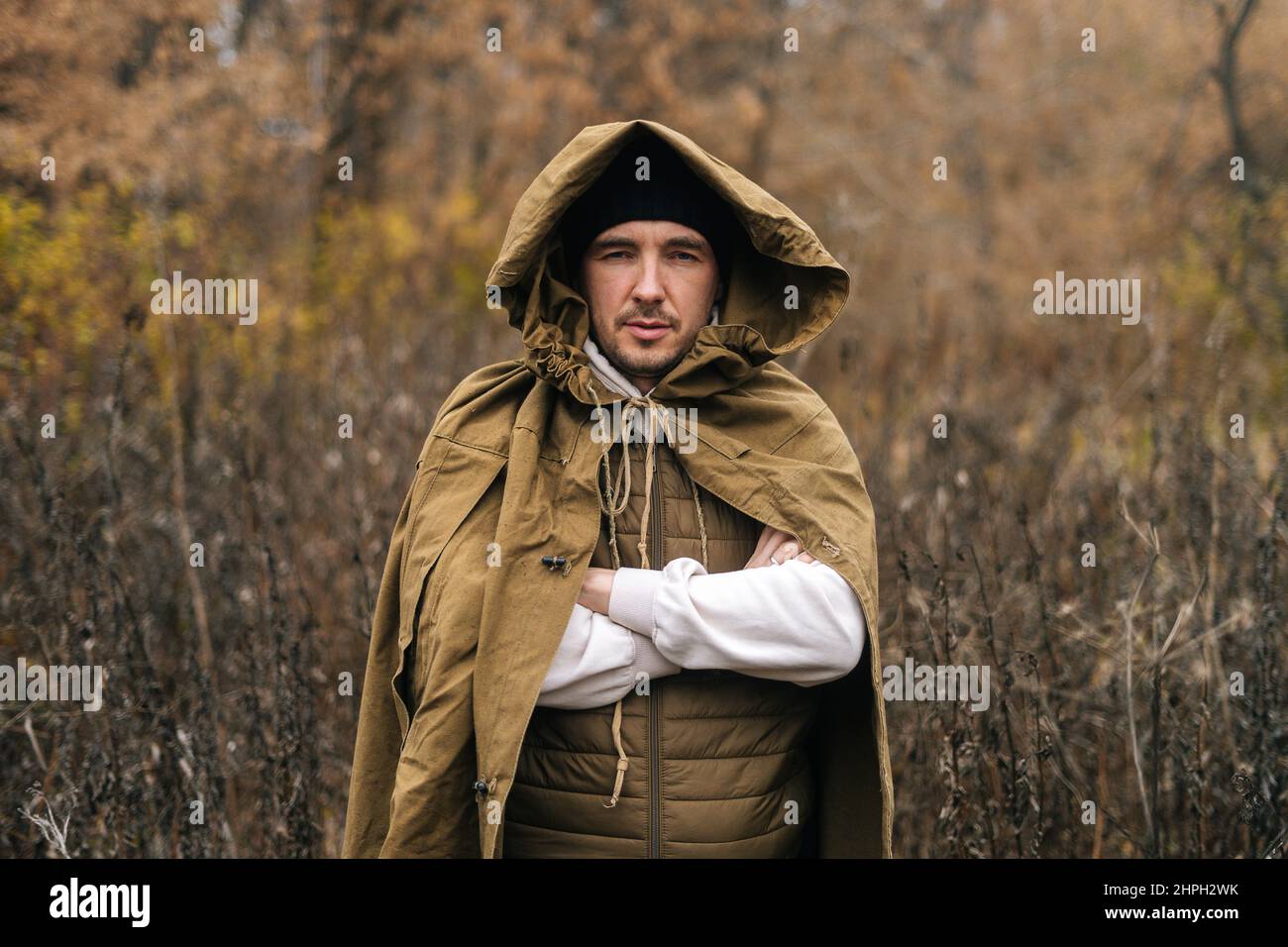 Portrait of confident hiker man in raincoat tent standing with crossed ...