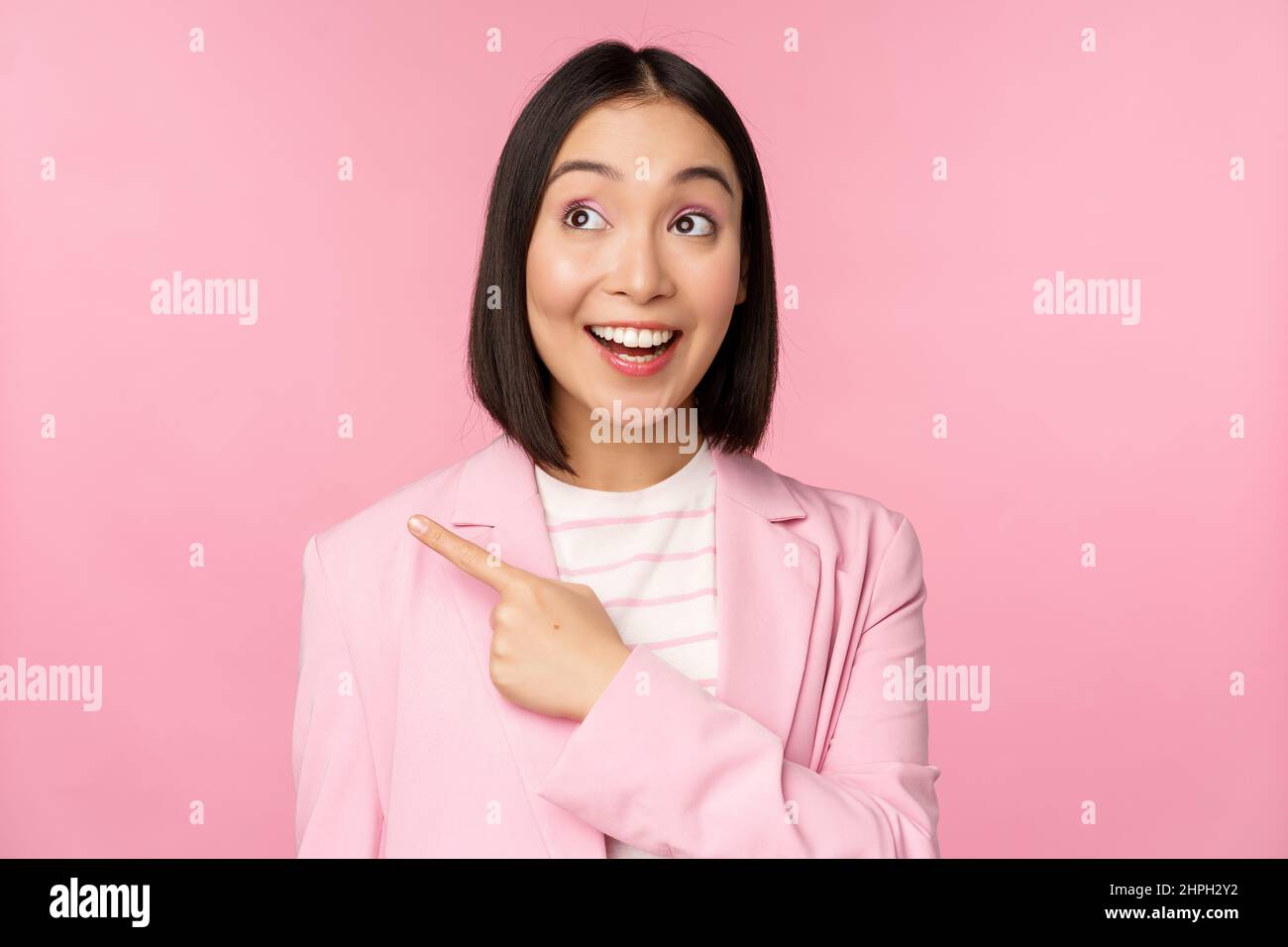 Enthusiastic young asian businesswoman, office employee pointing finger ...