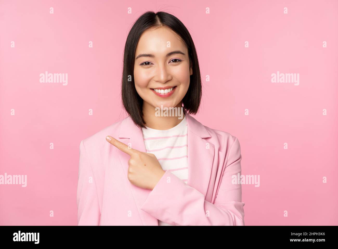 Portrait of asian business woman, saleswoman in suit pointing finger ...
