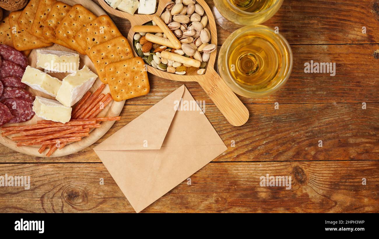Cheese and meat plate with an envelope. An invitation to a romantic ...