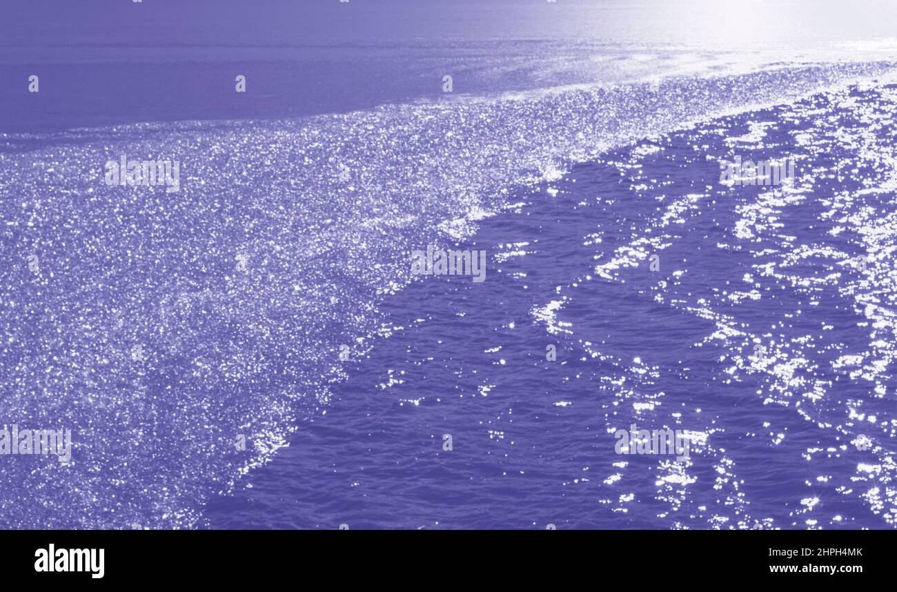 Winter sea water with gentle waves and a long bank of floating ice ...