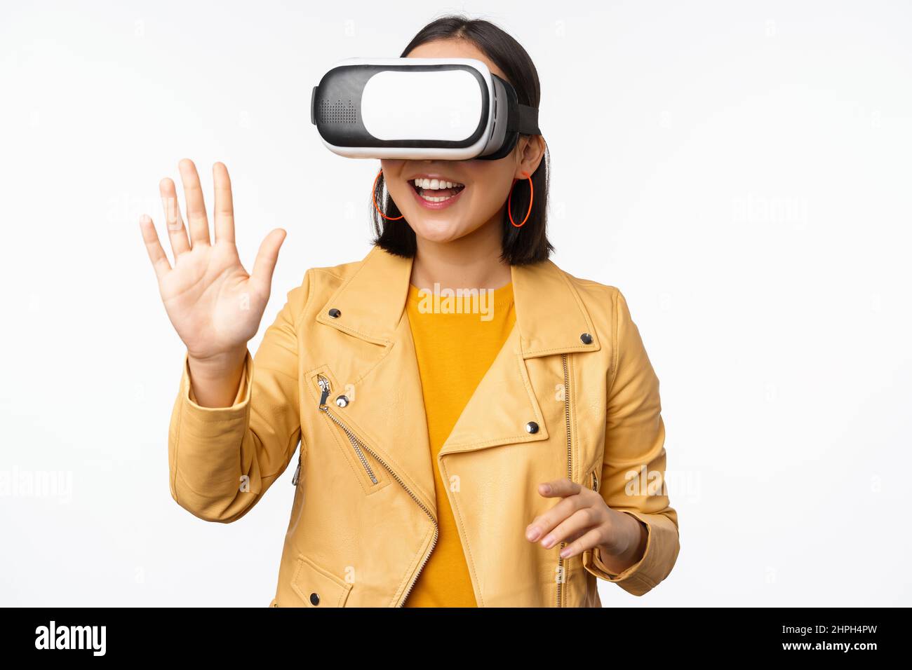 Happy asian girl in VR headset, saying hello in virtual reality chat ...