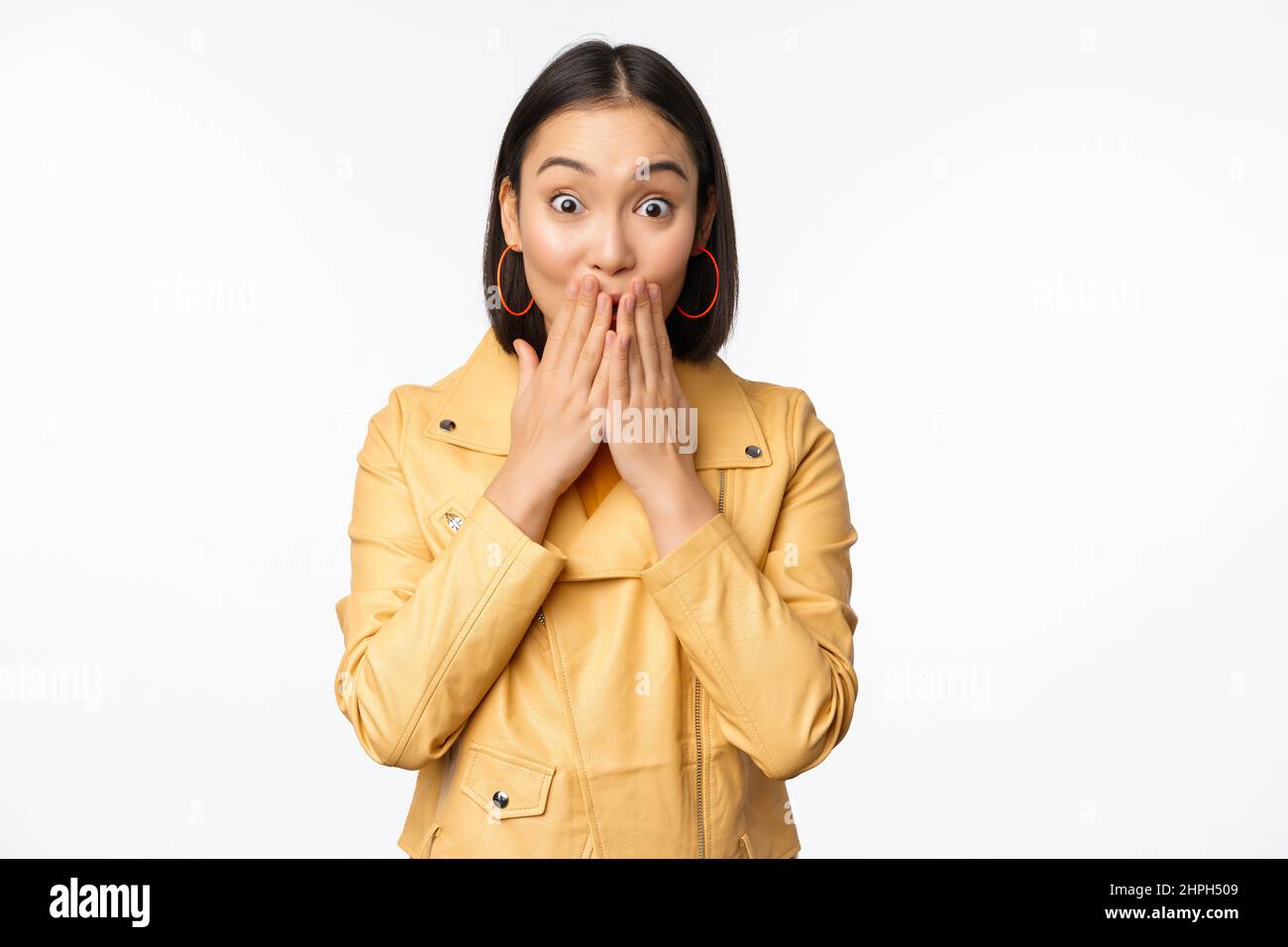 Portrait of excited asian girl looking with interest at camera, amazed ...