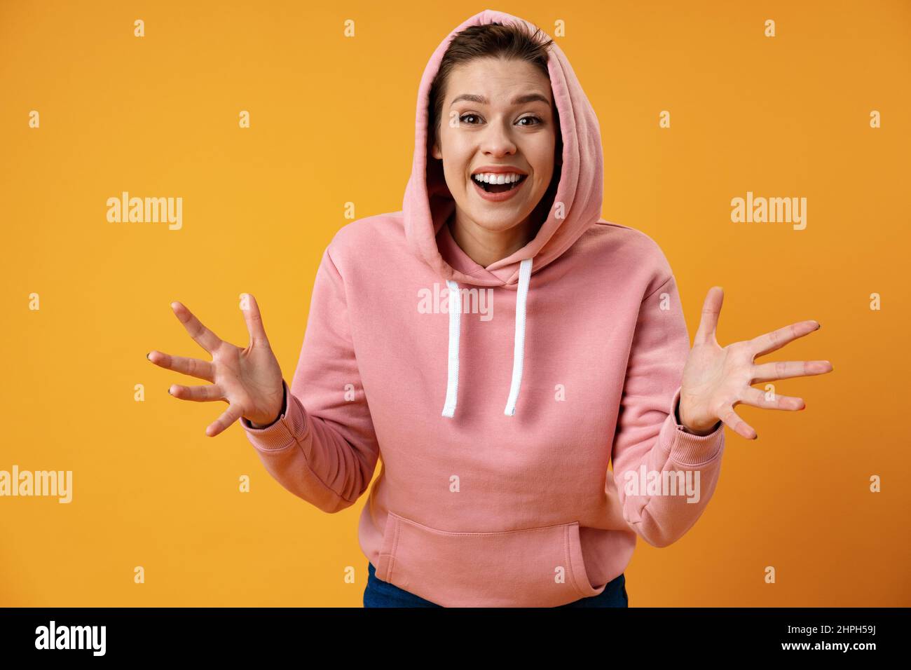 Surprised happy beautiful woman looking in excitement over yellow ...