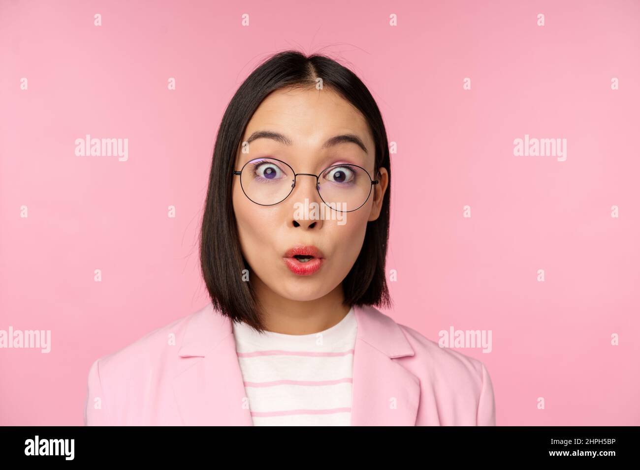 Close up portrait of asian businesswoman in glasses looking surprised ...