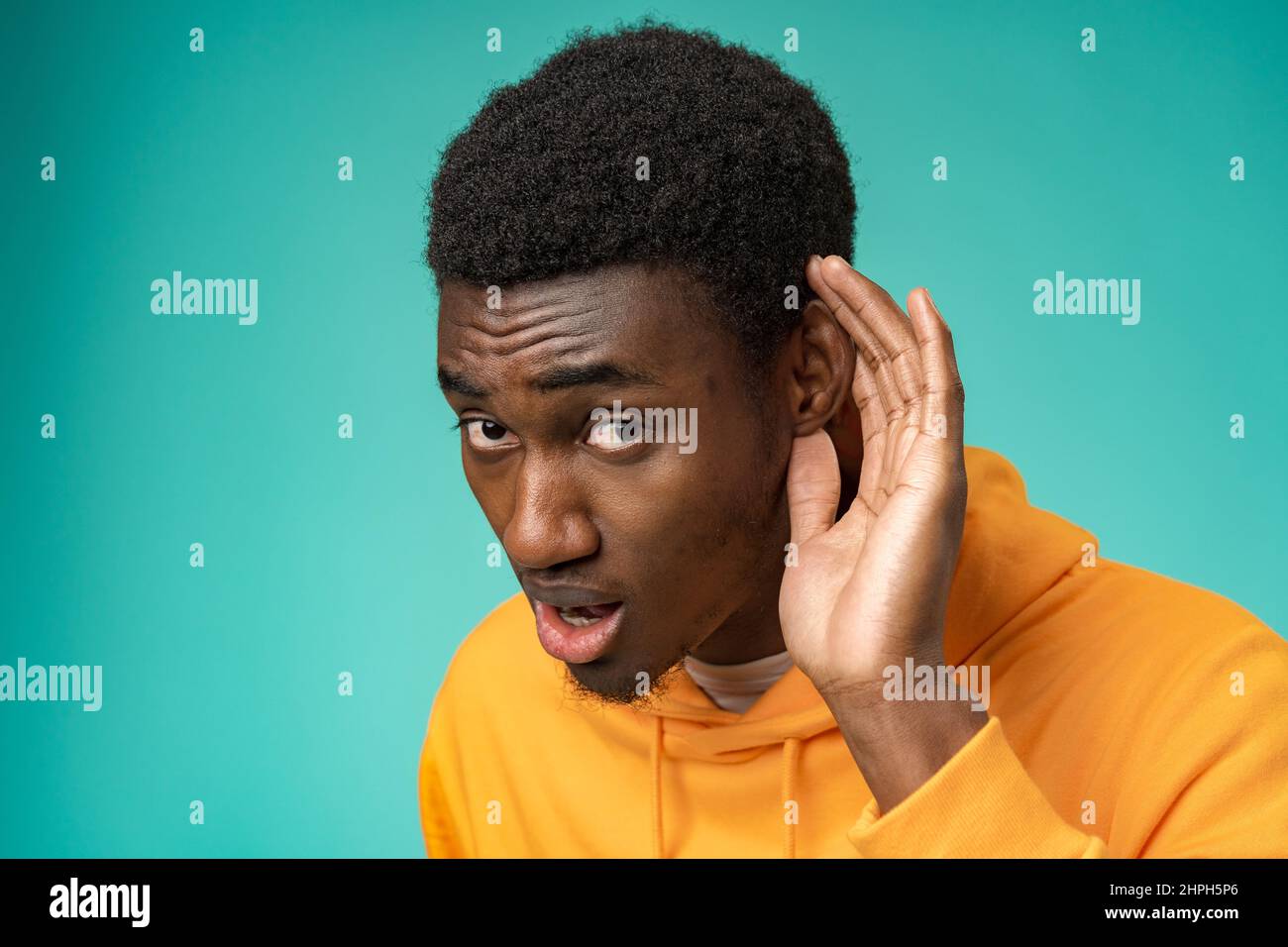 Portrait of attentive man putting hand to ear listening carefully Stock ...