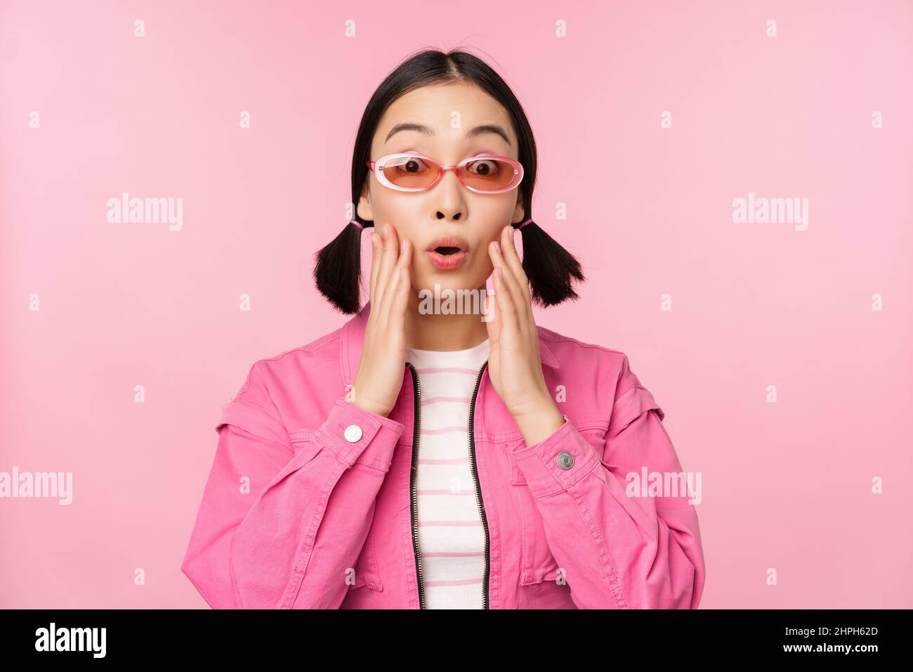Image of asian girl looking surprised and excited, smiling, amazed ...