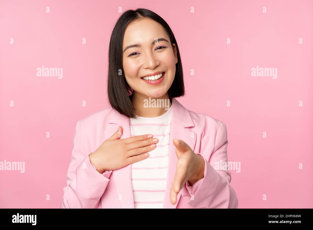Portrait of smiling, pleasant businesswoman shaking hands with business ...