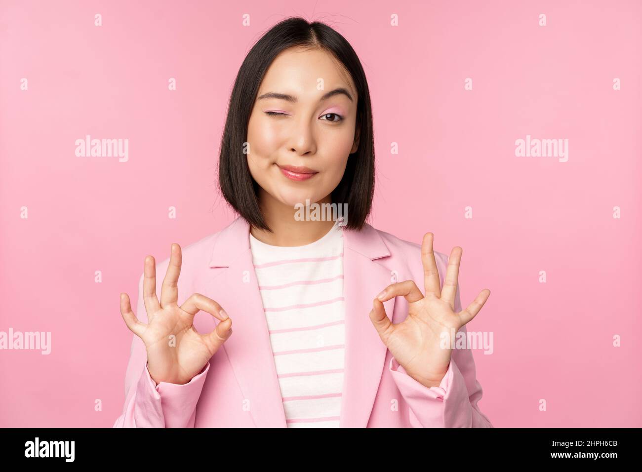 Okay, excellent. Businesswoman in corporate suit, showing ok, approval ...