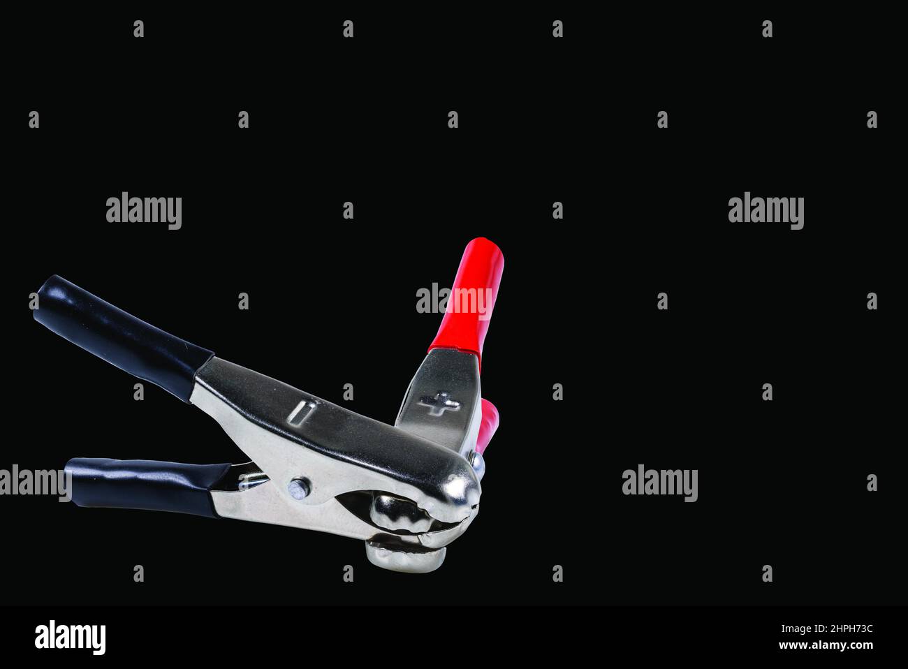 Close up view of two clips for charging battery isolated on black ...